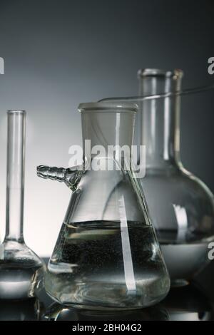 Fixed laboratory glassware on dark background Stock Photo - Alamy