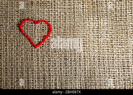 Linen canvas with red heart embroidered on it, close-up Stock Photo - Alamy