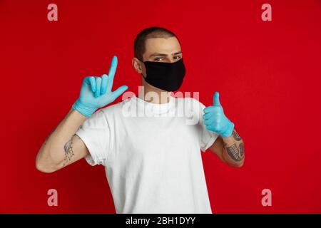 Handsome man with red facial covid-19 mask and t-shirt smile with blue ...