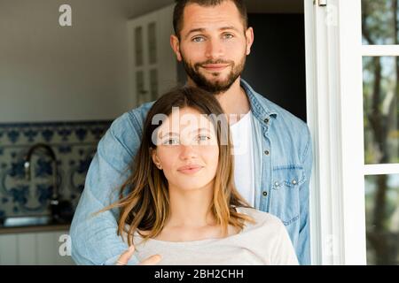 Portrait of happy young couple at door step Stock Photo - Alamy