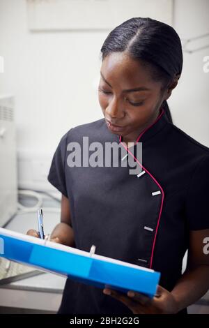 Dental assistant writing notes Stock Photo - Alamy