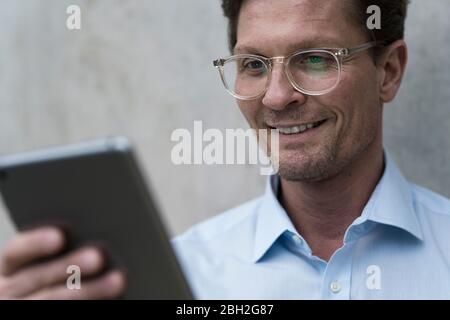 Happy and confident businessman using tablet Stock Photo - Alamy