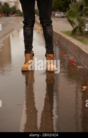 Young man standing in puddle on sports stadium on background of high ...