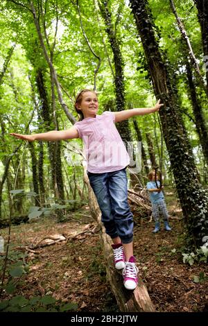 Caucasian girl balancing on log at Lake Louise, Banff, Alberta, Canada ...