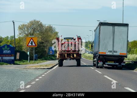Farm vehicle driving in traffic on A127 arterial, road Essex. Slow ...