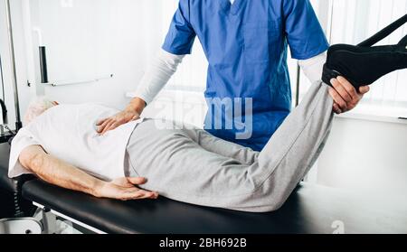 kinesiologist doing therapeutic exercises for an elderly patient ...
