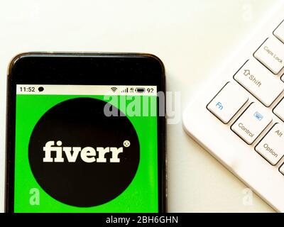 In this photo illustration, the Fiverr logo is displayed on a ...