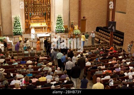Church members walk down center aisle to alter for rite of holy ...