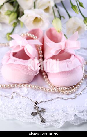Baby shoe, flowers and cross for Christening Stock Photo - Alamy