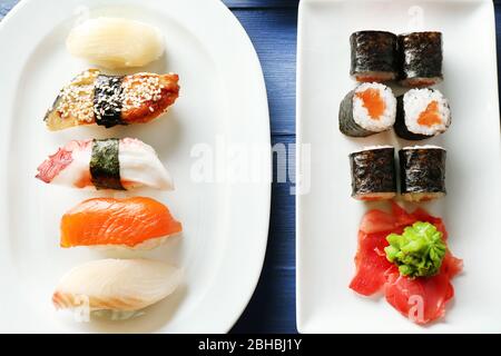 Sushi pieces collection on plates, on wooden background Stock Photo - Alamy