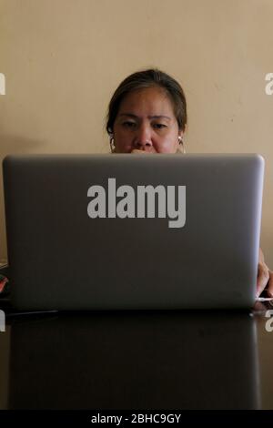 Filipino woman working on a computer Stock Photo - Alamy