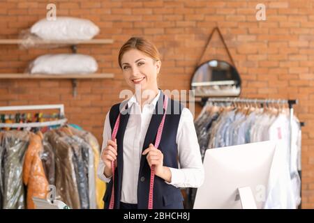 Worker of modern dry-cleaner's at reception Stock Photo - Alamy