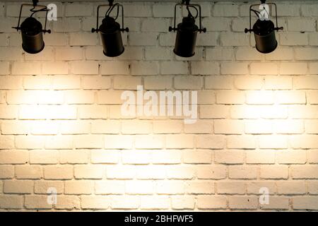 Hanging spotlight illuminate at brick wall background with copy space ...