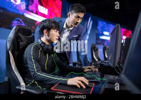 Young Chinese man coaching gamer playing esports Stock Photo - Alamy