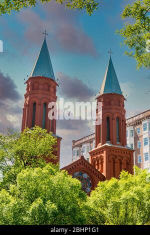 A brick building with a steeple and a blue roof. The building is tall ...