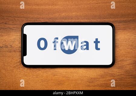 A smartphone showing the Ofwat logo rests on a yellow background along ...