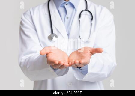 Closeup of unrecognizable doctor holding invisible object on his open ...