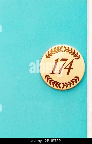 House number 174 on a round sign with laurel painted on Stock Photo - Alamy
