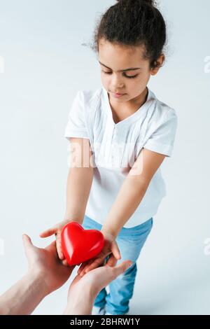 Man and kid holding red heart in hands at wooden table, closeup Stock ...