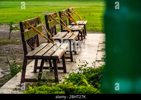 Park benches with yellow warning tape and a notice of closure. Parks ...