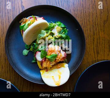 Fresh sliced octopus tentacles served as sashimi on round wooden board ...