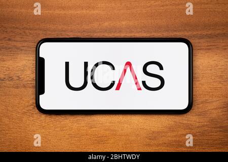 A smartphone showing the UCAS logo rests on a yellow background along ...