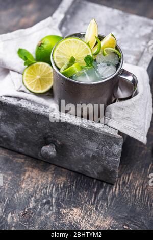 Moscow mule alcoholic cocktail in copper mug with lime, mint and ...