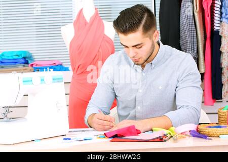 Young man fashion designer creates new collection of clothes Stock ...