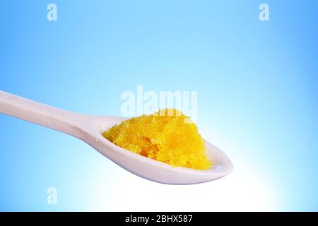 Laboratory spatula with granules on blue background Stock Photo - Alamy