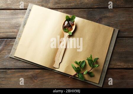 Open recipe book with mint leaves on wooden background Stock Photo - Alamy