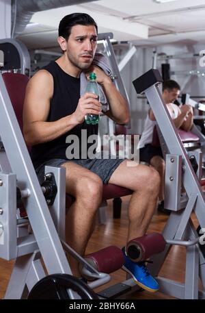 Portrait of strong sporty man resting during workout in gym Stock Photo ...