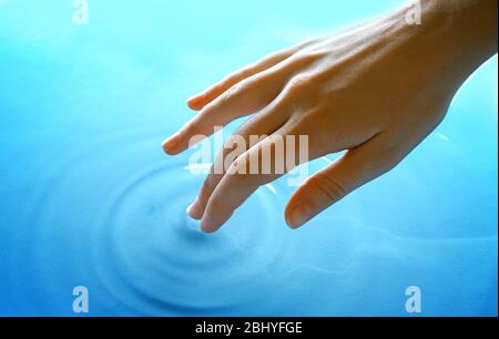 Finger touches water close up Stock Photo - Alamy
