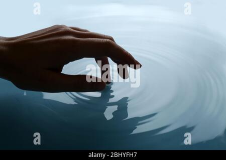 Finger touches water close up Stock Photo - Alamy