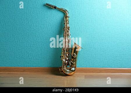 Saxophone on turquoise wallpaper background Stock Photo - Alamy