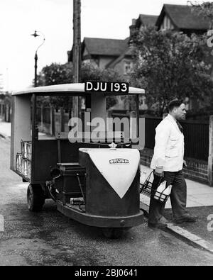 Milkman delivering milk from a milk float in Bath, Somerset, England ...