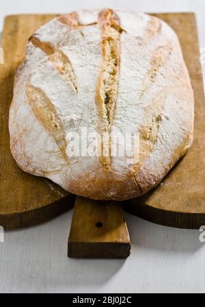 loaf of breads on a wooden cutting board on a table Stock Photo - Alamy