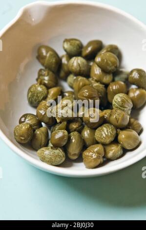 Small white bowl of Italian capers Stock Photo - Alamy
