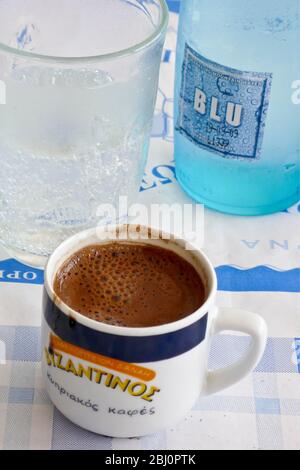 Small cup of sweet strong, Greek coffee on cafe table in southern ...