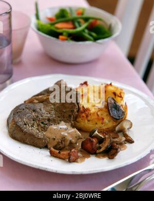 Beef steak with potatoes on a white plate Stock Photo - Alamy