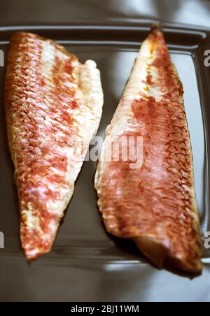 Raw red mullet fish fillets garnished with lemon, parsley and fennel ...