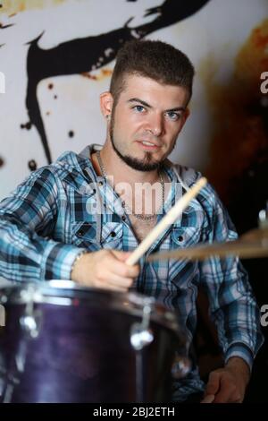 Excited drummer on bright background Stock Photo - Alamy