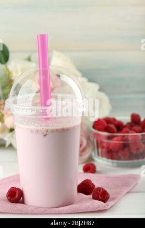 Plastic cup of milkshake on light background, outdoors Stock Photo - Alamy