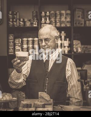 Sepia front view of 1940s man as vintage shopkeeper, grocer, in WW2 ...