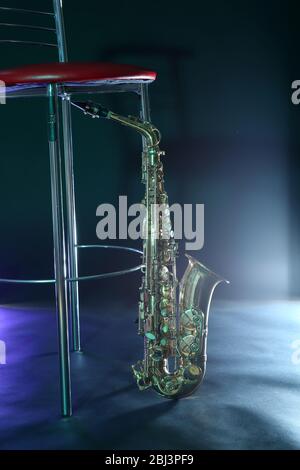 Beautiful golden saxophone near bar stool on a scene Stock Photo - Alamy