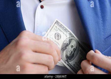 Man hiding dollar banknotes in cabinet indoors, closeup. Money savings ...