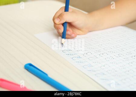 Schoolkid learns to write on sheet of paper, closeup Stock Photo - Alamy