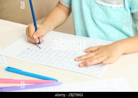 Schoolkid learns to write on sheet of paper, closeup Stock Photo - Alamy