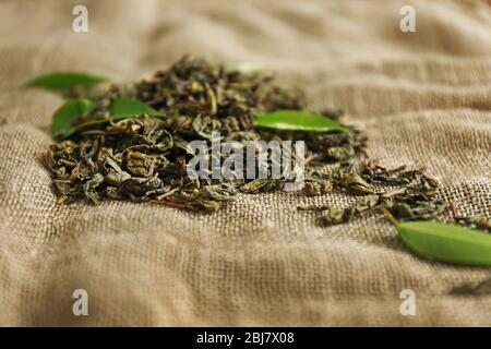 Granulated tea with green leaves on grey background Stock Photo - Alamy