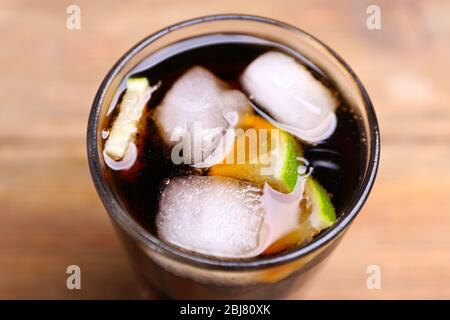 Cocktail with lime slices and ice blocks on wooden table, top view ...