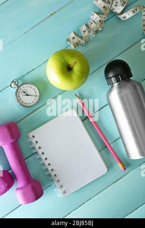 Athlete's set with equipment, notebook and bottle of water and apple on ...